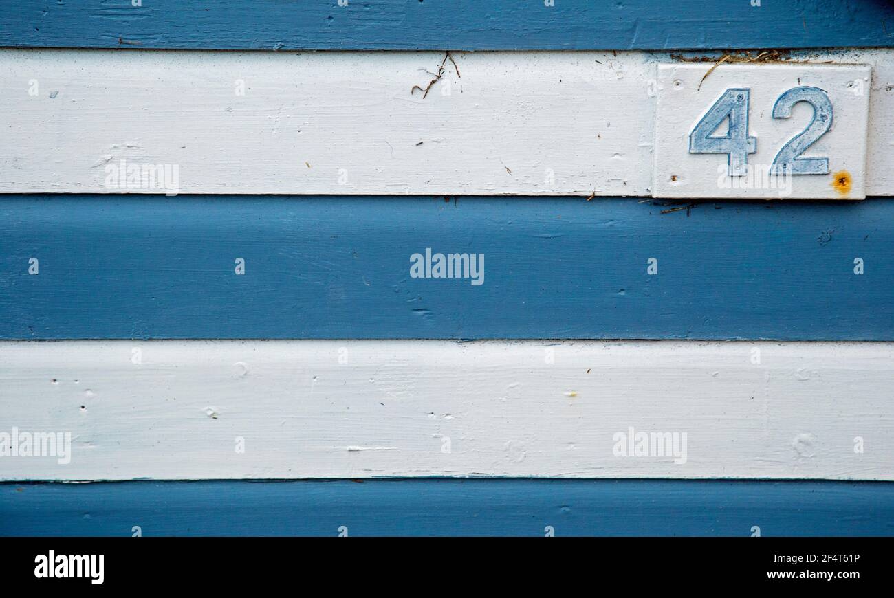 Landscape shot of a blue and white striped painted beach hut with the ...