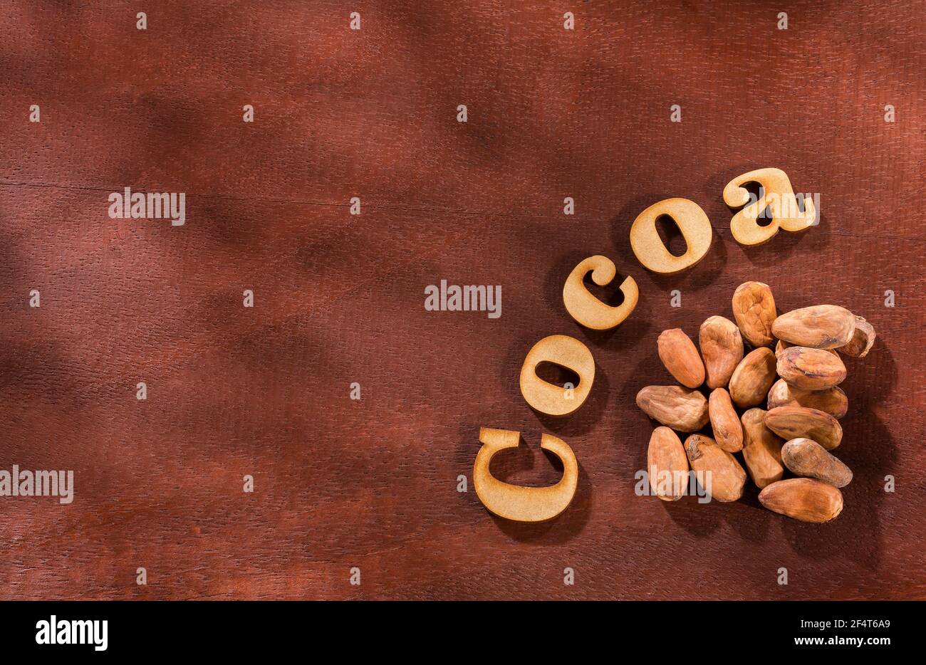 Organic cocoa beans - Theobroma cacao. Cocoa word in wooden letters ...