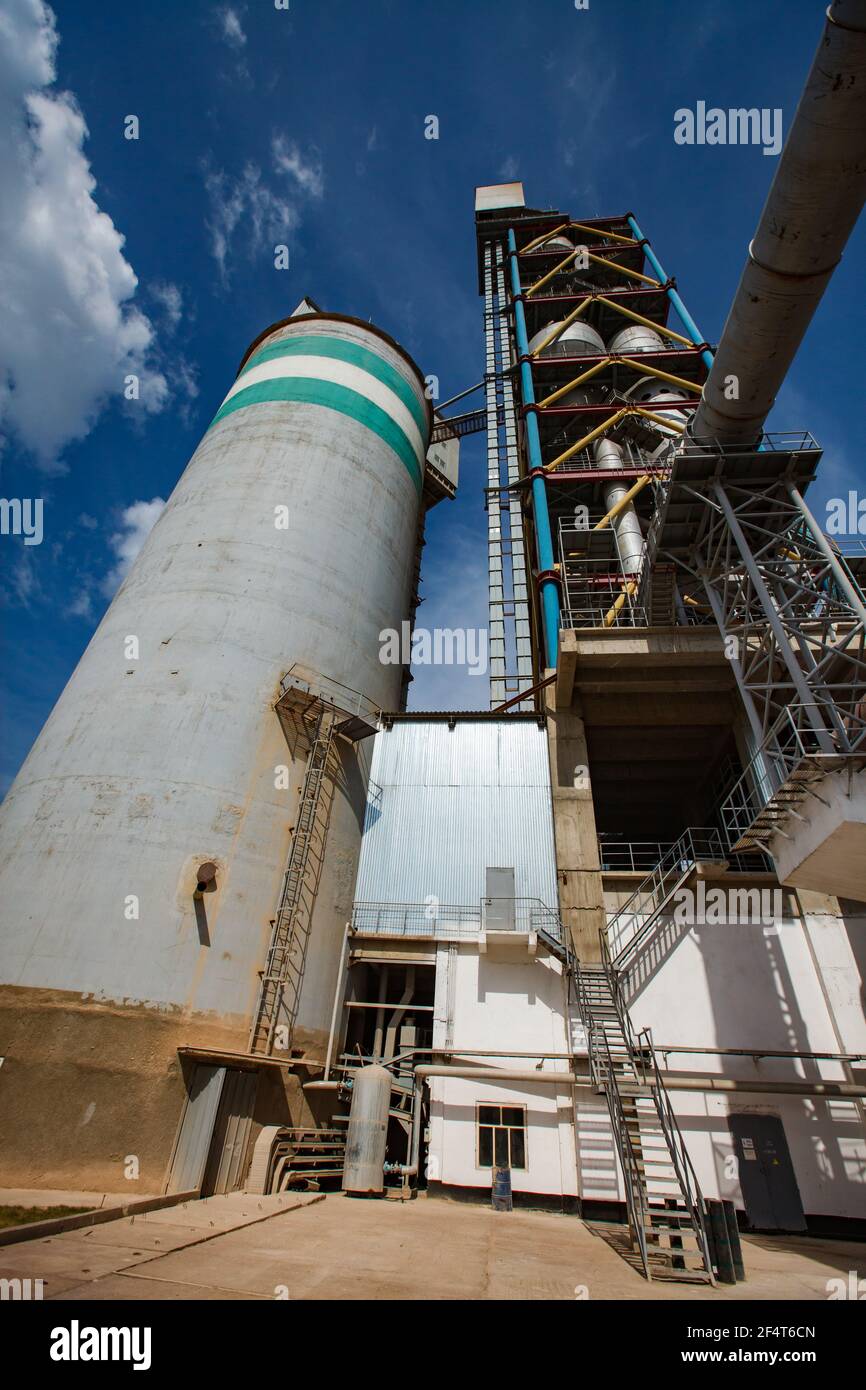 Standard Cement plant. Mixing tower and concrete silo on blue sky ...
