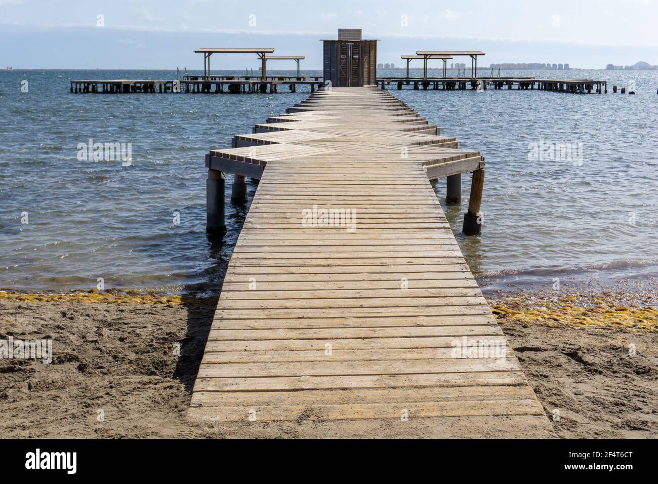 A wooden boardwalk leading out into the ocean to a public bath ...