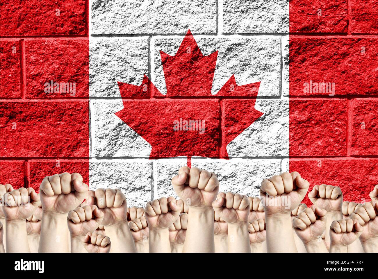 Raised fists against the background of the depicted flag of Canada on a ...