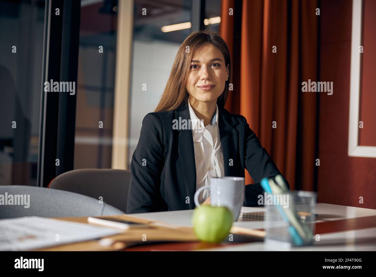 Serene pretty lady seated in the workplace Stock Photo - Alamy