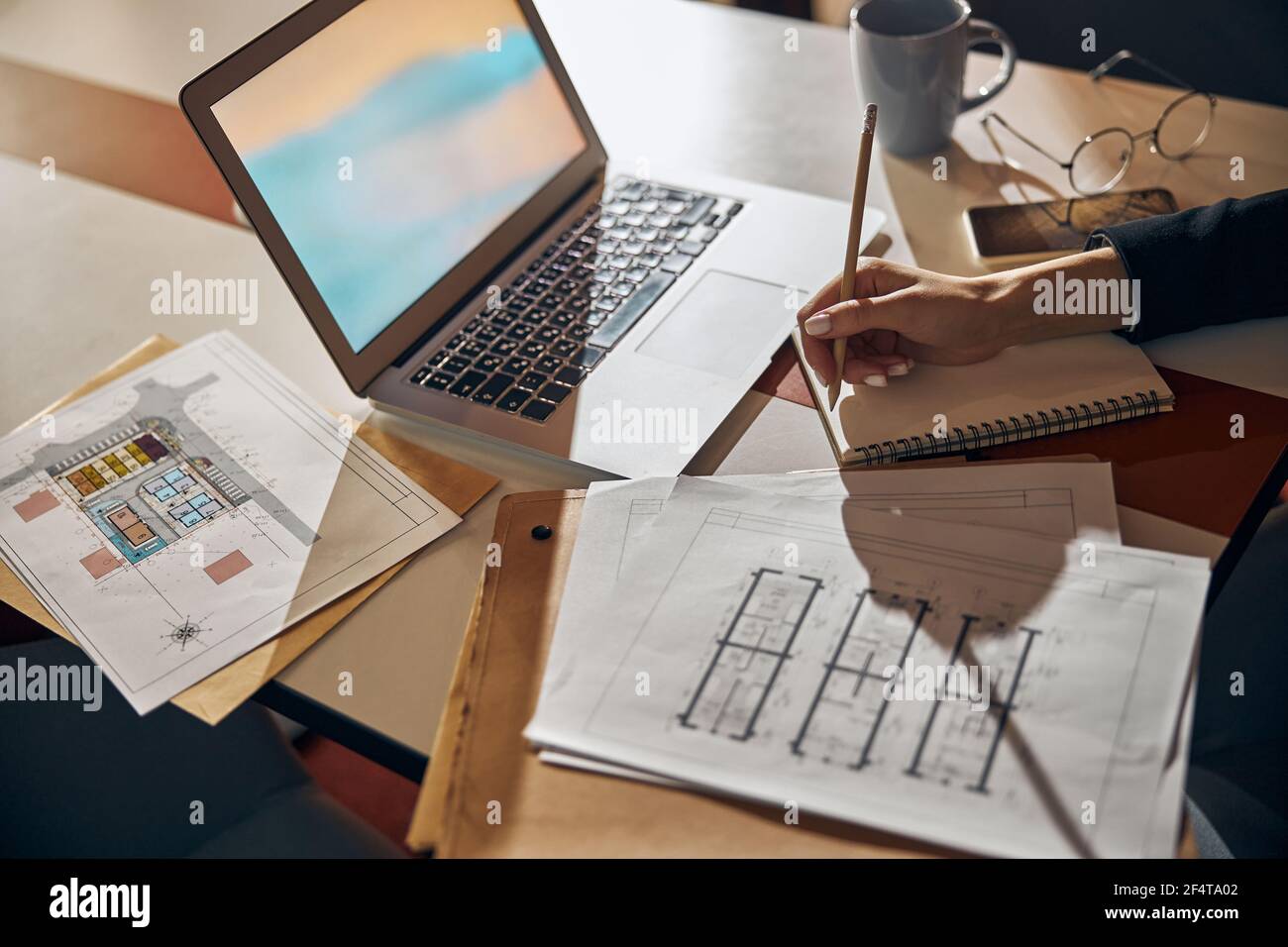 Engineer taking notes with a pencil at the desk Stock Photo - Alamy