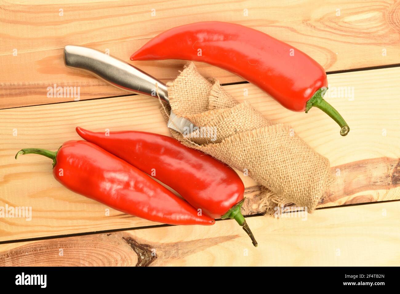 Three ripe organic tasty sweet Kapia peppers, with a metal knife and a ...