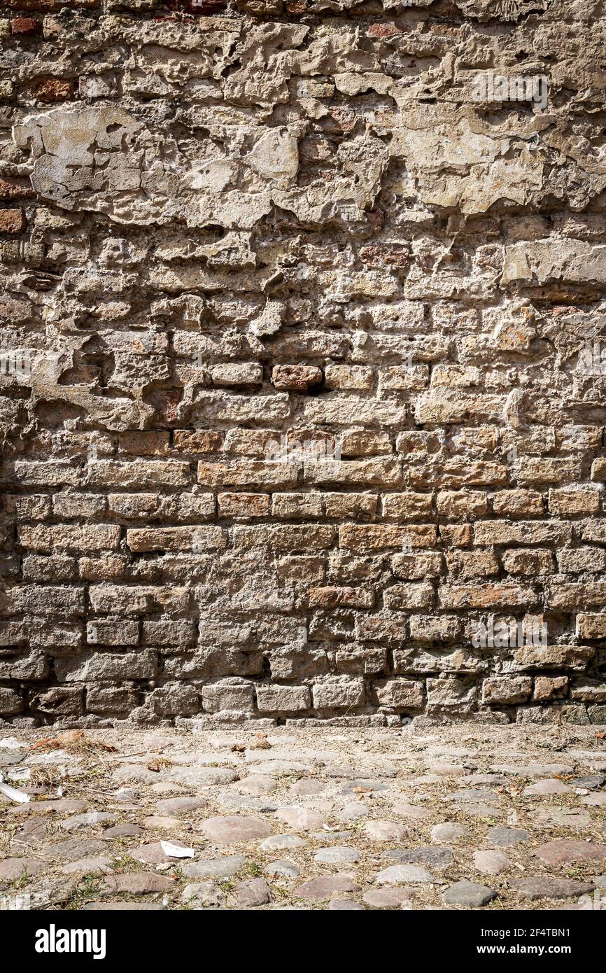 Old weathered wall of bricks and a cobblestone Stock Photo - Alamy