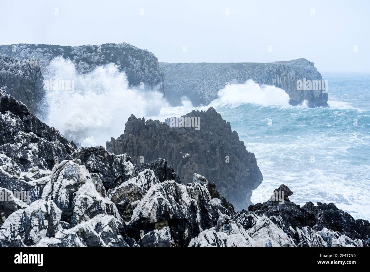Waves crashing against the karst limestone sea cliffs in Asturias ...