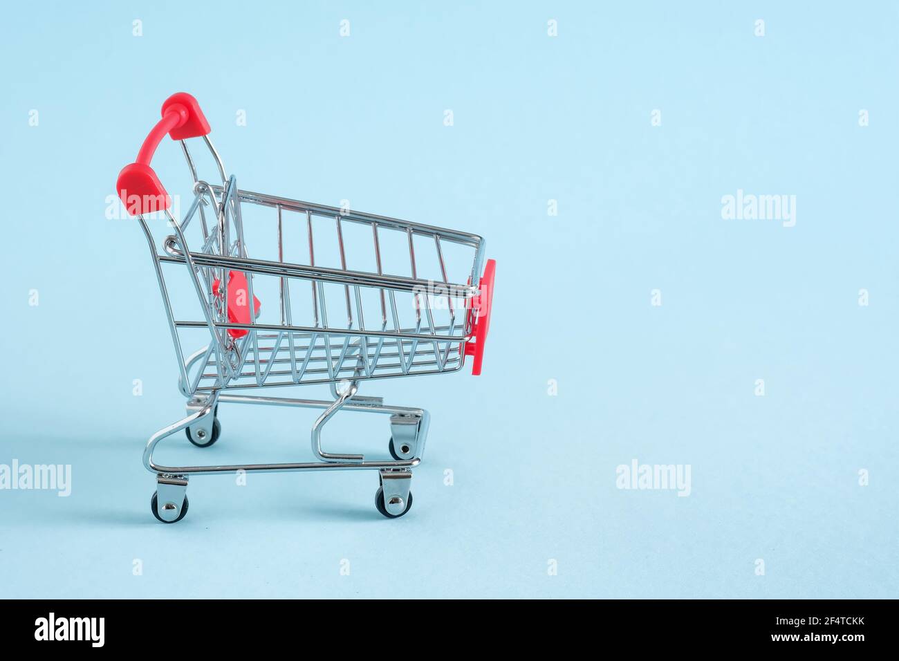 Empty shopping cart on blue background Stock Photo - Alamy