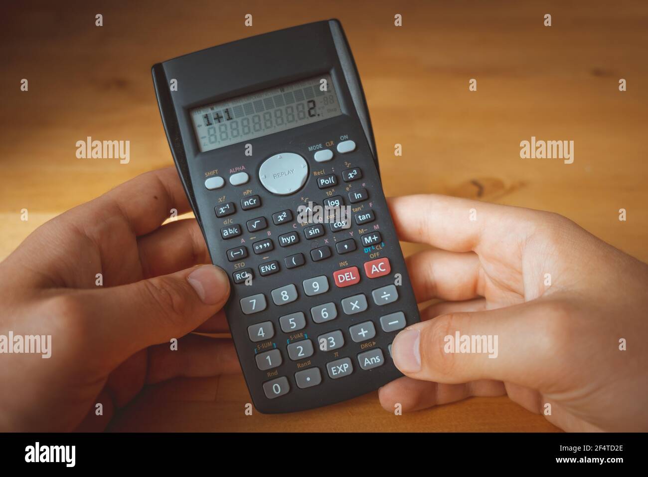Calculator in hands with the calculation 1+1=2 Stock Photo - Alamy
