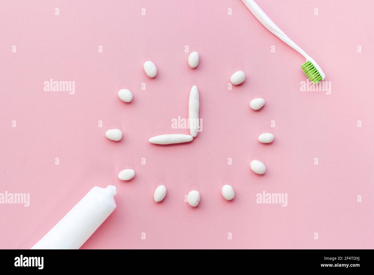 Morning routine concept. Clock made of toothpaste with toothbrushes ...