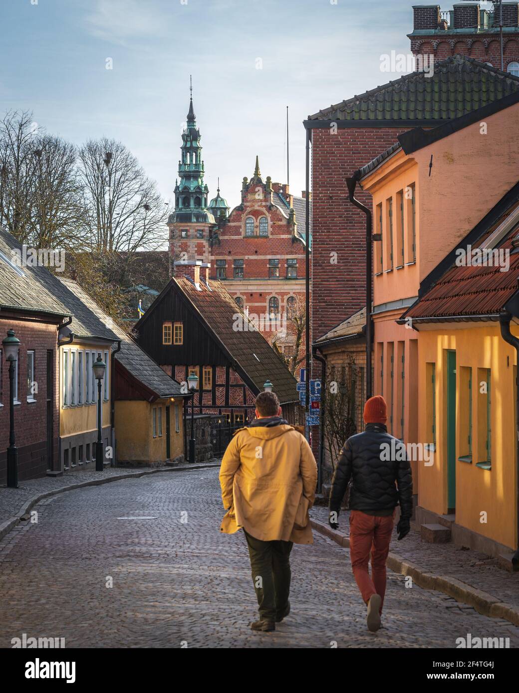 Two men walking down a cobbletoned street in the medieval historic town ...
