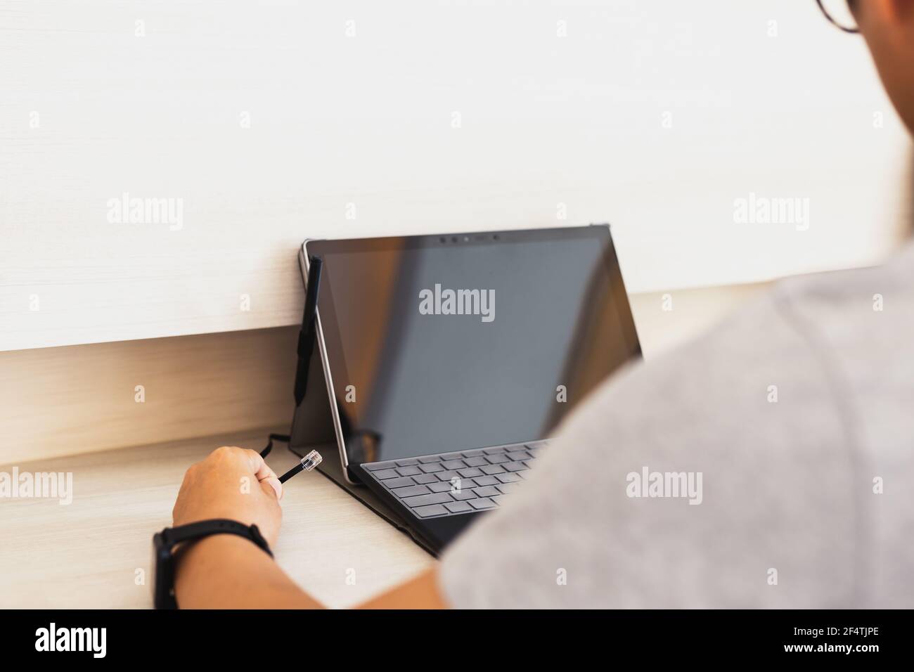 Man hand connecting internet cable wire to laptop Stock Photo - Alamy