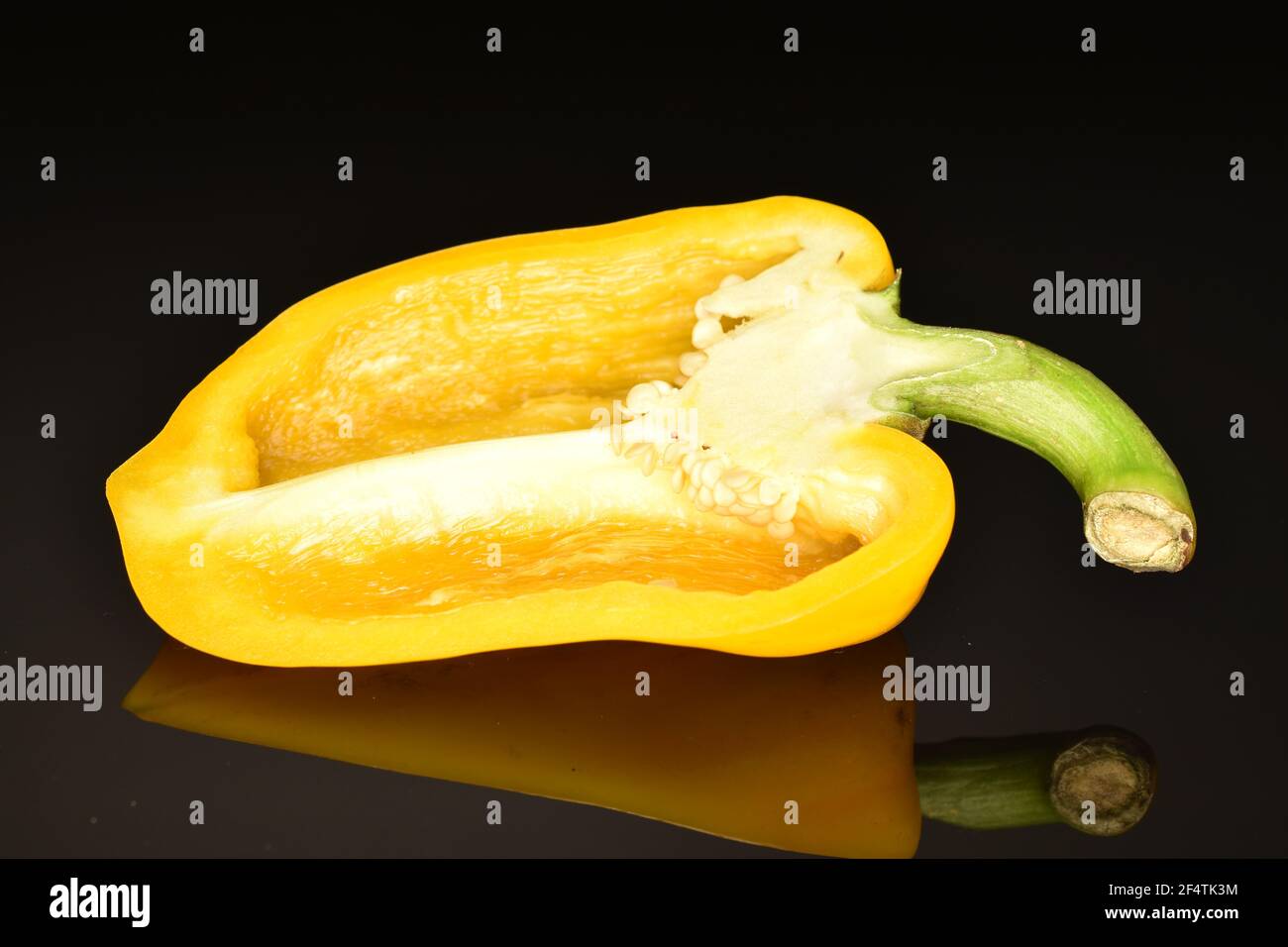 One half, organic ripe juicy bell pepper, close-up, on a black ...