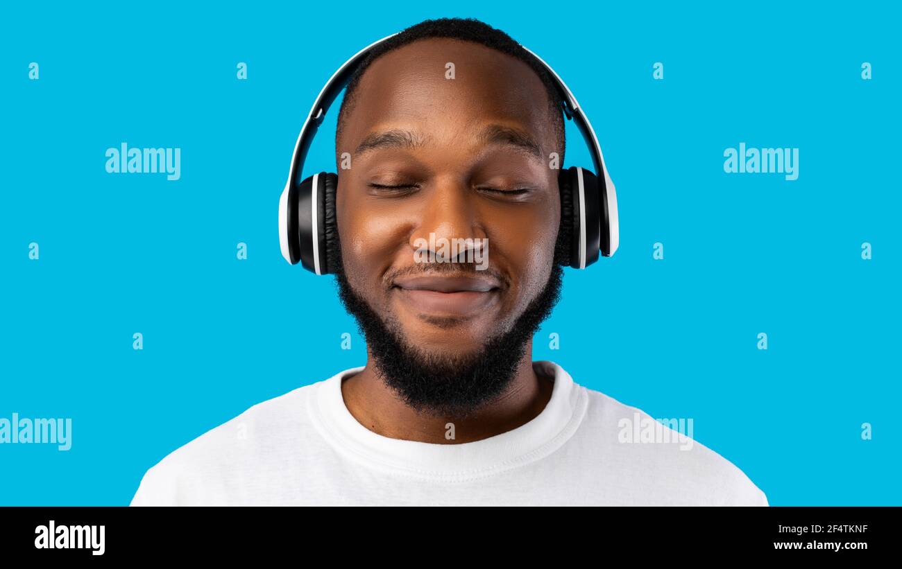 African American Man Wearing Headphones Listening To Music, Blue ...