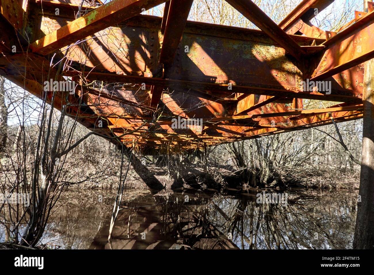 Underside with the iron struts of a rusty old railroad bridge over the ...