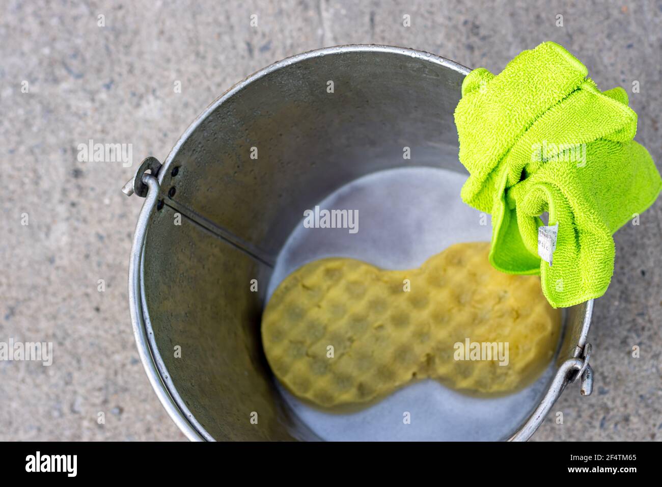 A washing sponge with a cloth in a bucket Stock Photo - Alamy