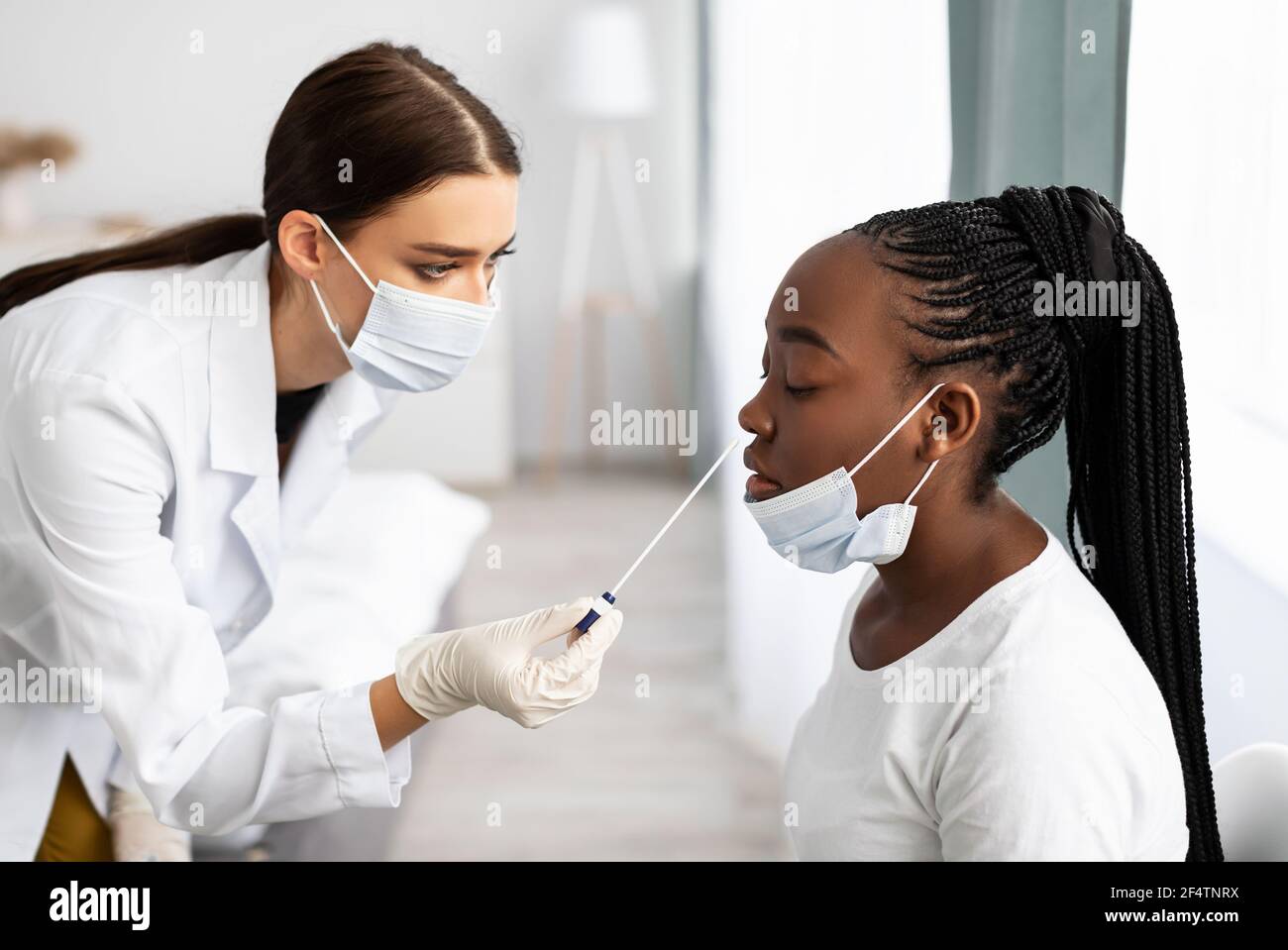 Doctor taking PCR test sample from potentially infected black woman ...