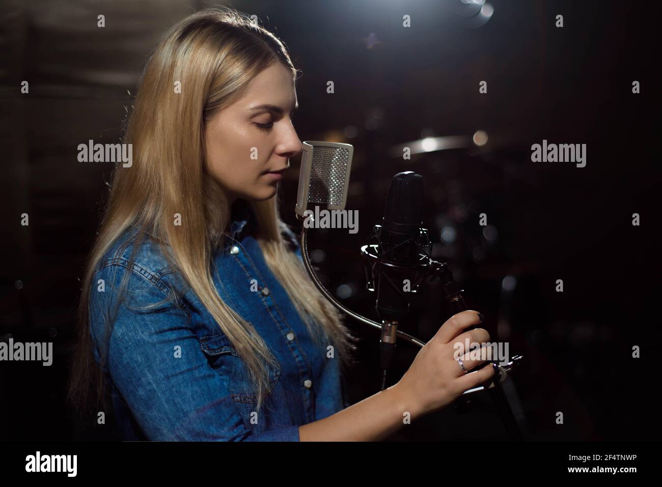 Blonde singing woman in a recording studio Stock Photo - Alamy