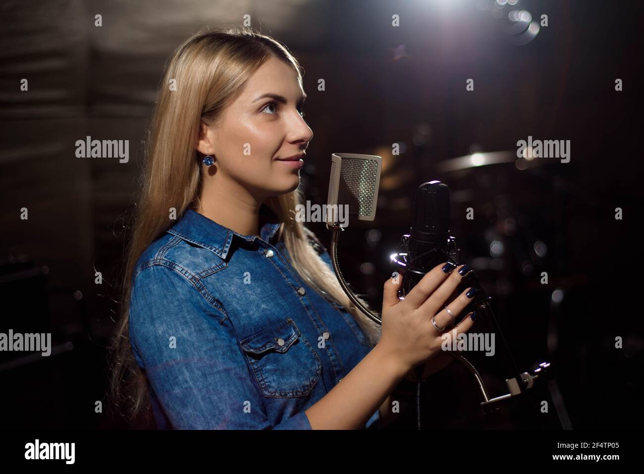 Female singer singing a song. Woman performing in a recording st Stock ...
