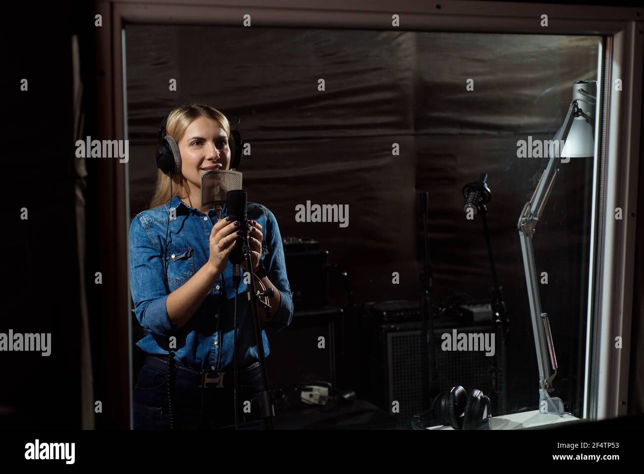 Female singing a sing with mobile phone at recording studio. You Stock ...