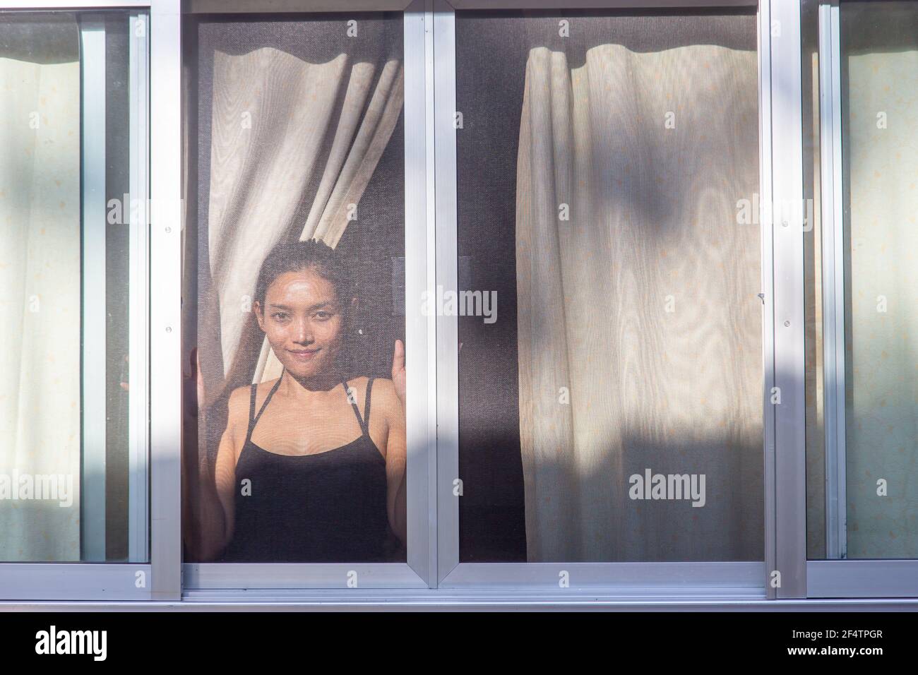 Young women through window hi-res stock photography and images - Alamy