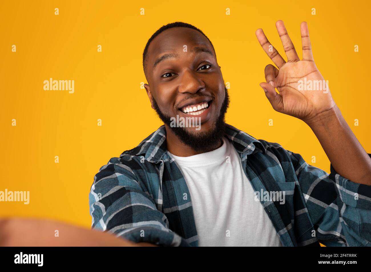 Happy Black Guy Gesturing OK Making Selfie Over Yellow Background Stock ...
