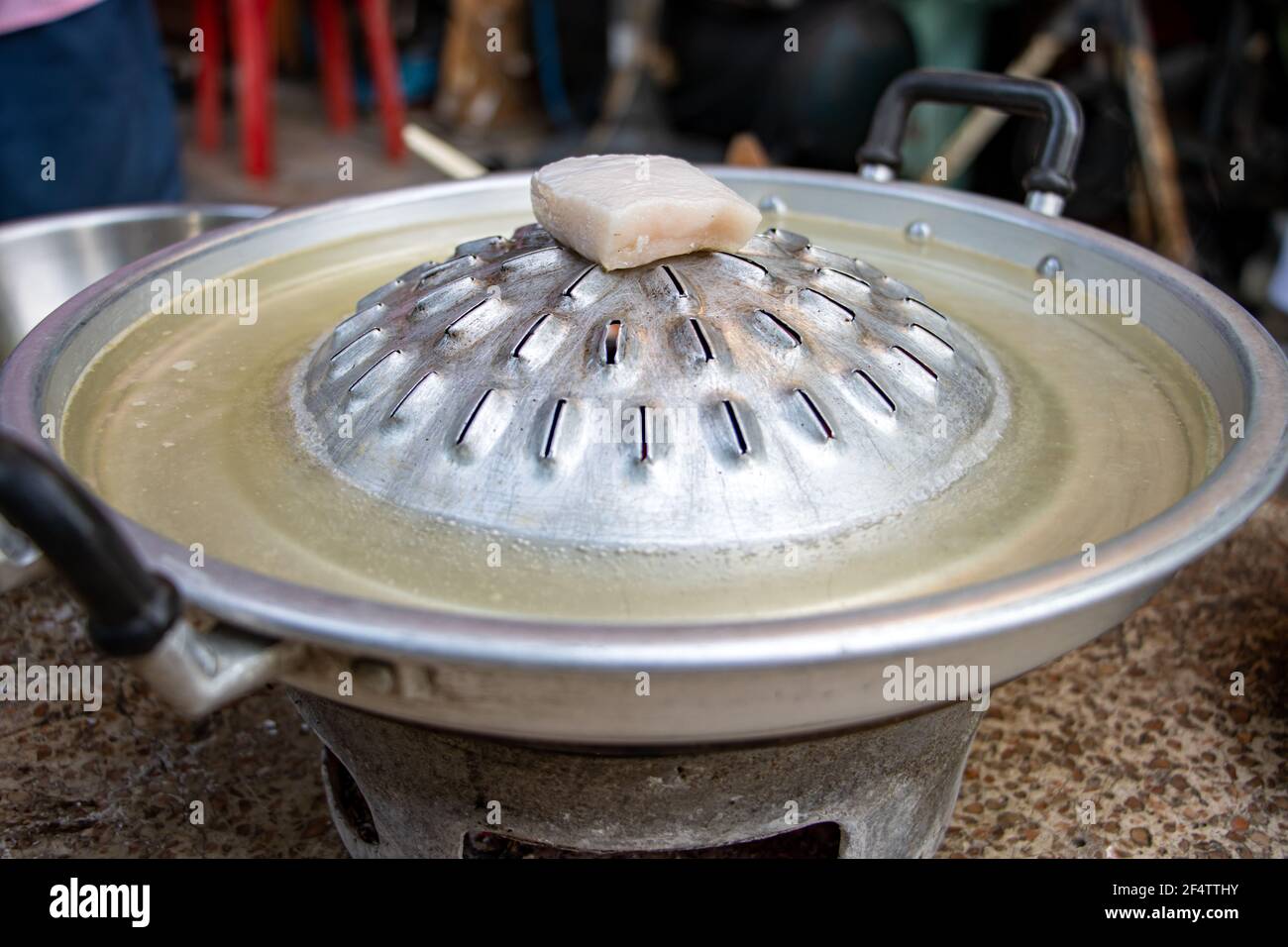 The cube of the fat is dissolved in a hot pan for grilling at Thai ...