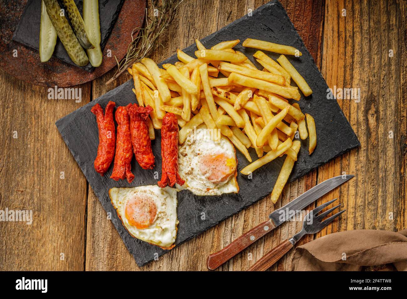 close up of a black plate of fried egg with french fries. Fast food ...