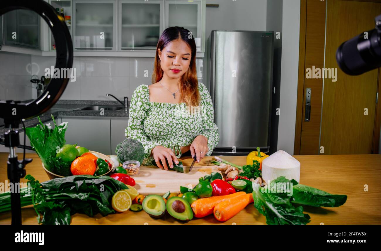 Asian woman blogger or content creator cooking and recording video ...