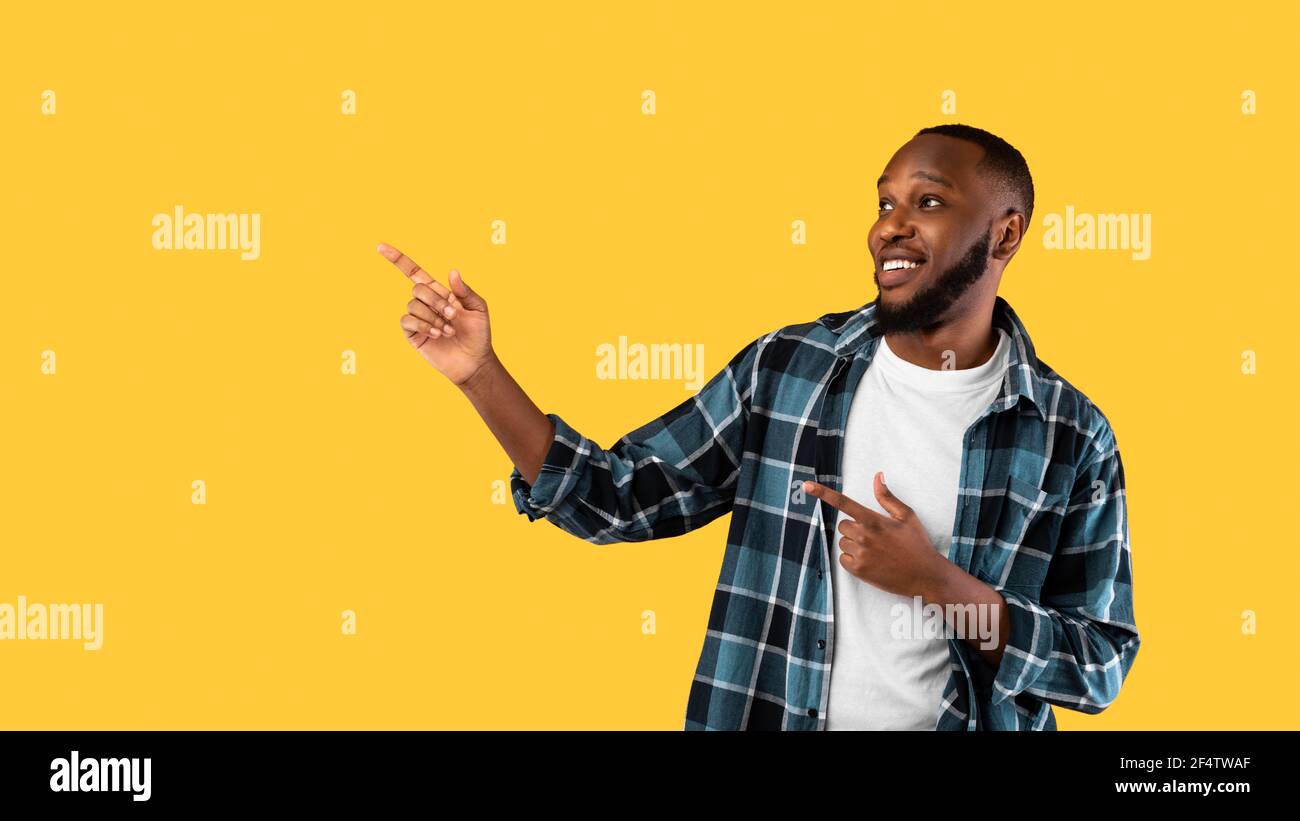 Positive Black Man Pointing Fingers Aside Standing Over Yellow ...