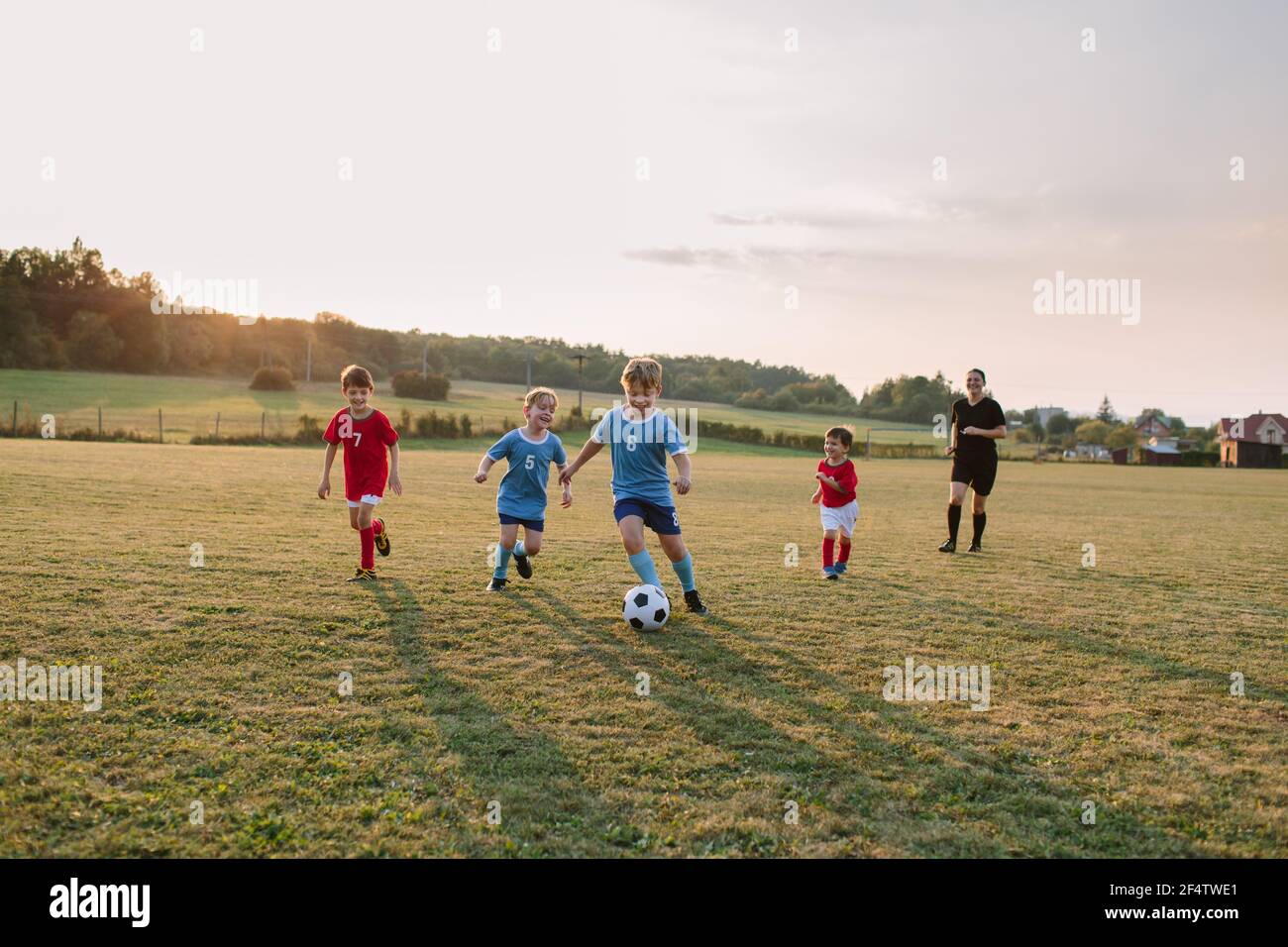 Children playing soccer. Full length of cheerful boys in football ...