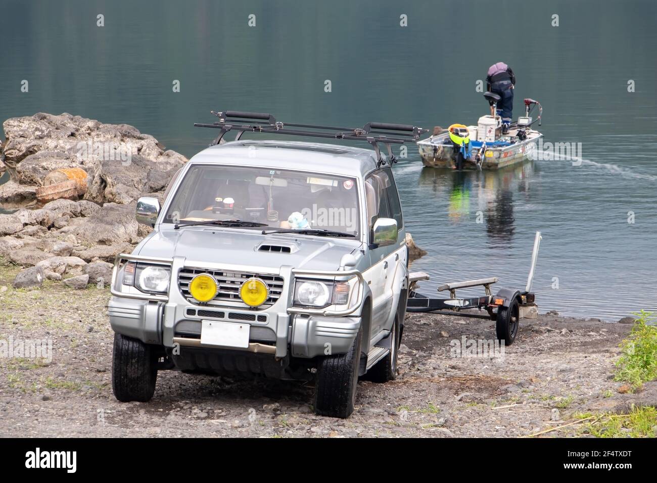 The car with a trolley for transit a boat on the shore of the lake, in ...