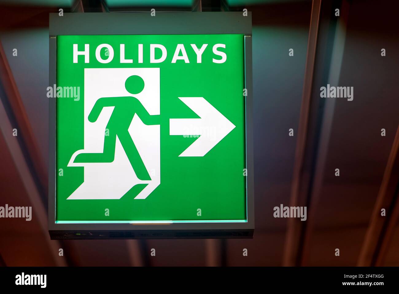 The emergency exit sign indicates the direction of way to holidays ...