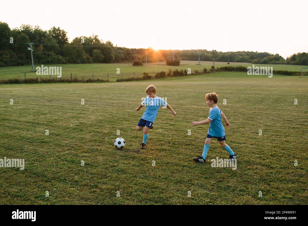 Children running after soccer ball. Front view of young boys in ... Children running after soccer ball. Front view of young boys in ...