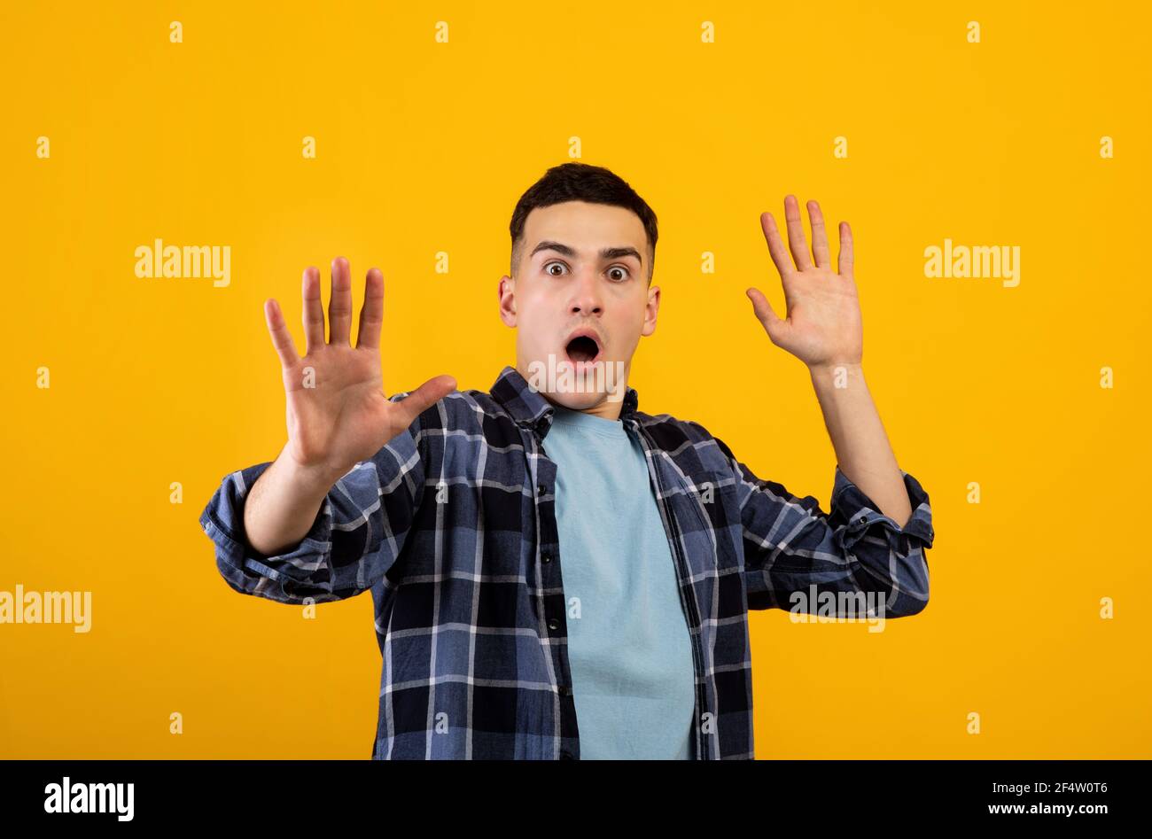 Scared Caucasian guy shouting in panic, making STOP gesture with both ...