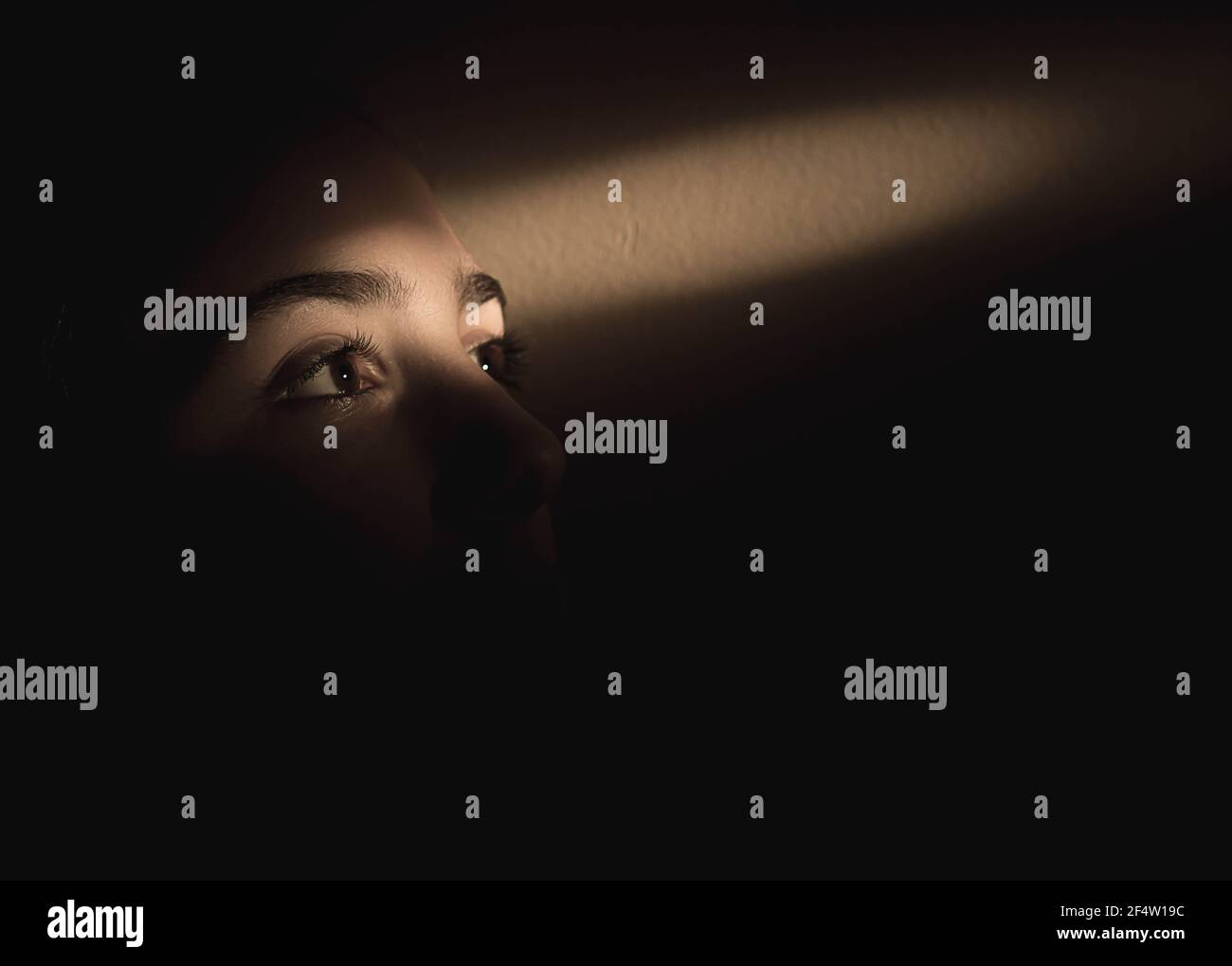 Single ray of light falling over girls eyes Stock Photo - Alamy