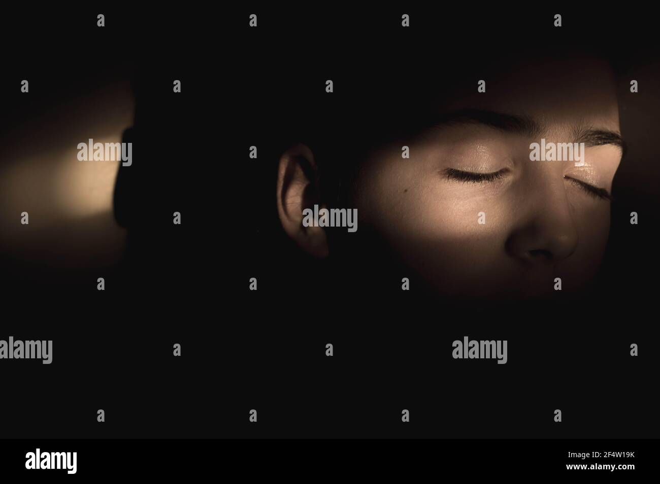 Single ray of light falling over girls eyes Stock Photo - Alamy