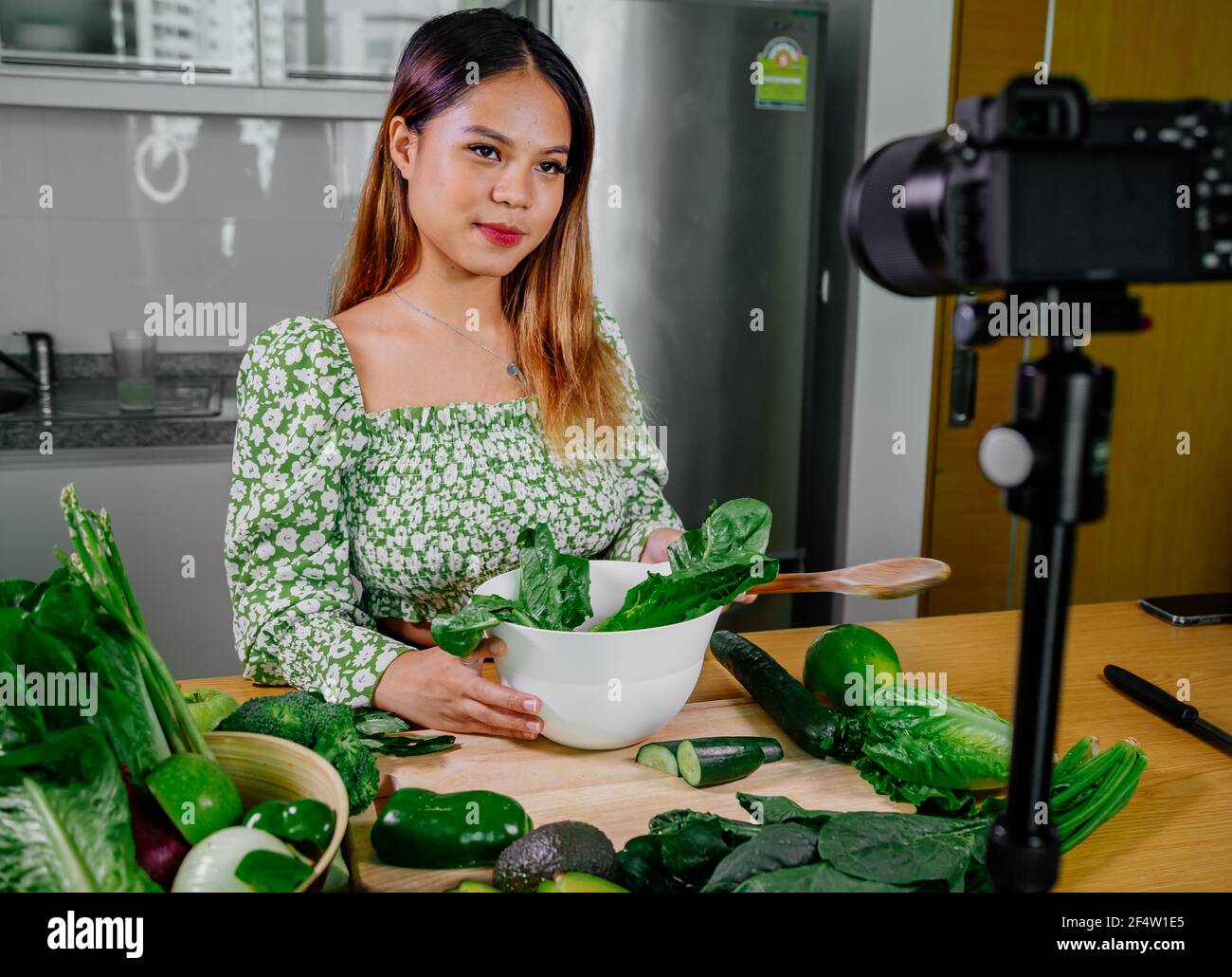 Asian woman blogger or content creator cooking and recording video ...
