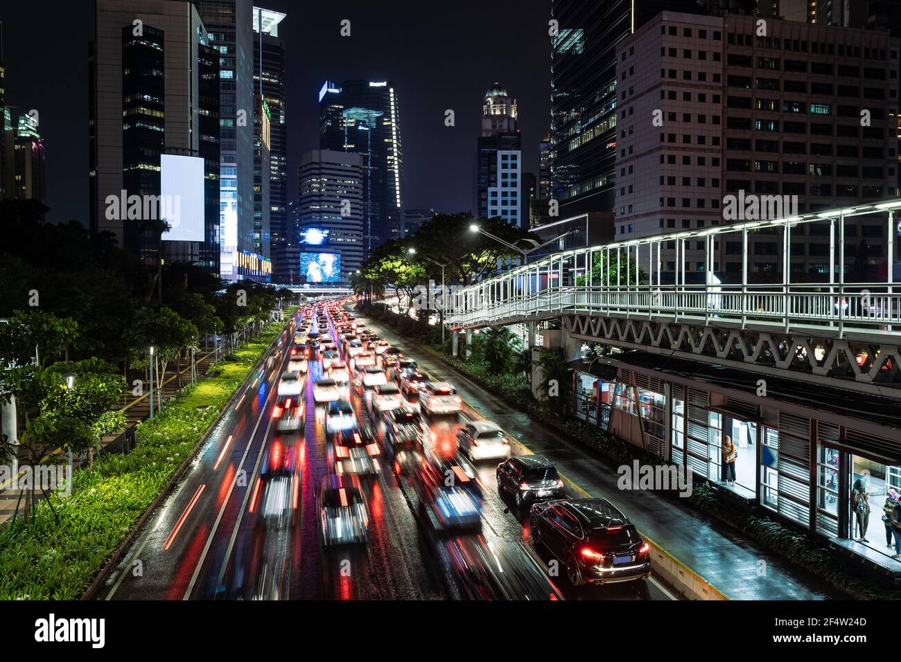 Traffic rushes aong the main avenue in the heart of Jakarta business ...
