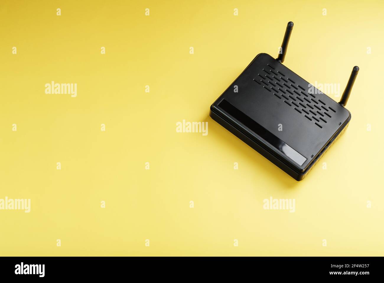 Black Wi-Fi router on a yellow background with free space. Isolate, top ...