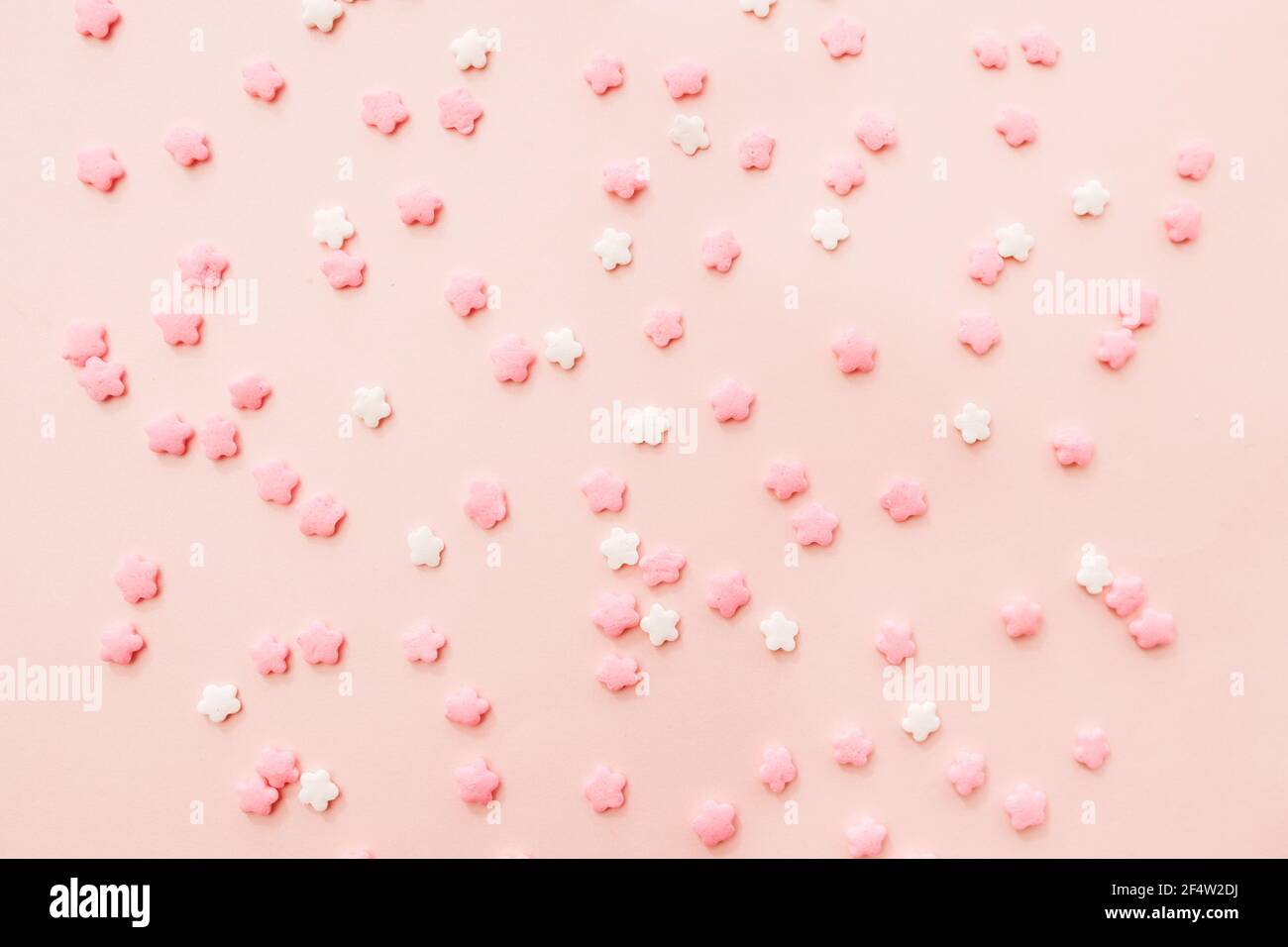Pink and white star shaped sprinkles on light pink background ...