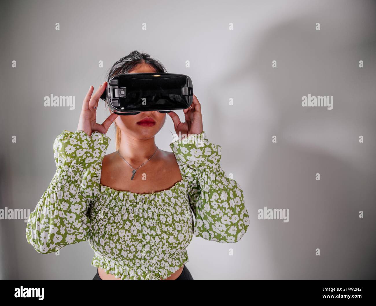 Asian Woman looking through virtual reality device at home. Augmented ...