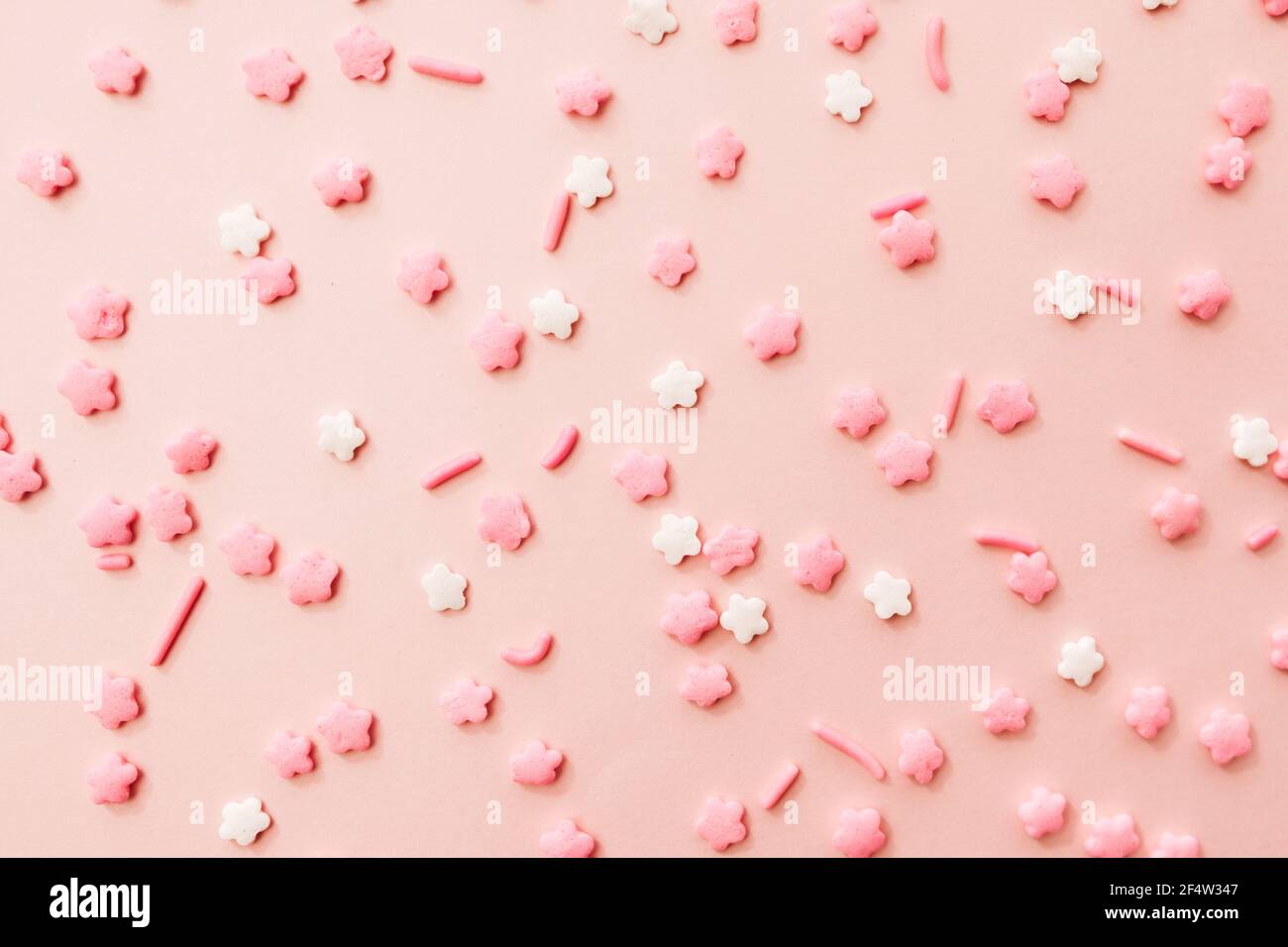 Pink and white star shaped sprinkles on light pink background ...
