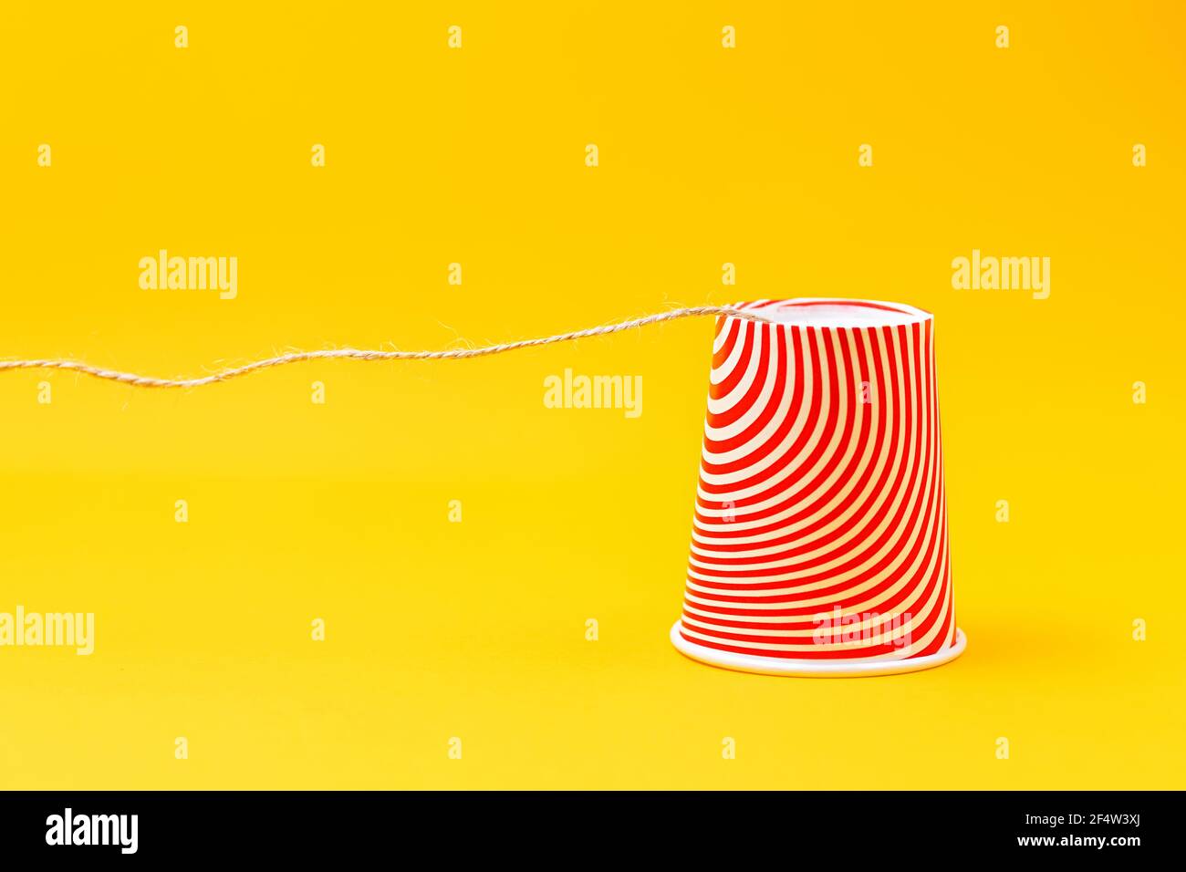 Close up of paper cup connected by a string. Children's homemade toy ...