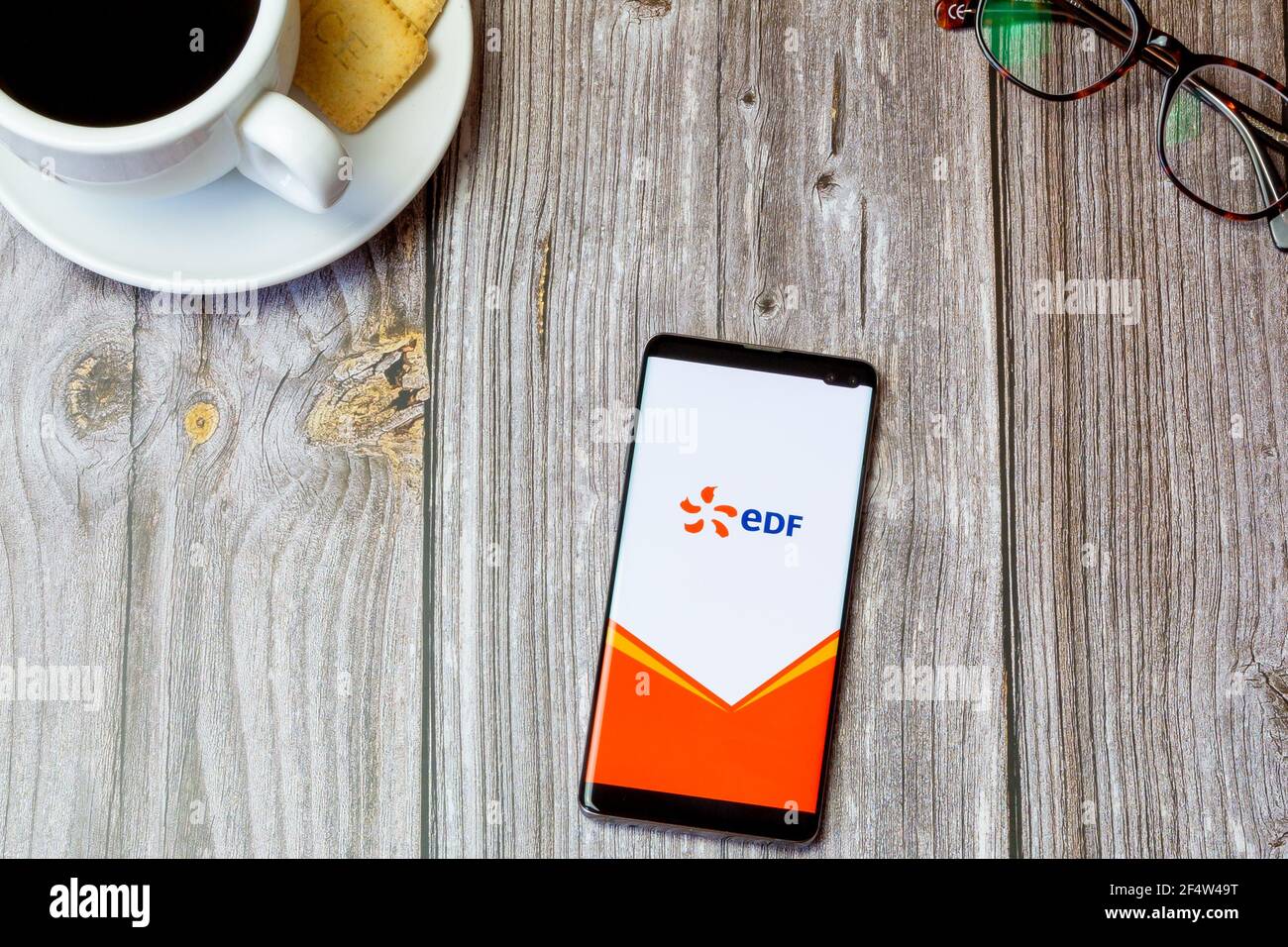 A mobile phone or cell phone laid on a wooden table with the EDF Energy ...