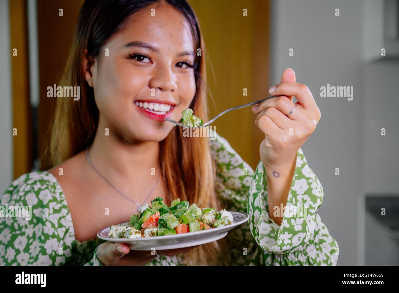 beautiful young asian woman eating healthy mediterranean food. smiling ...