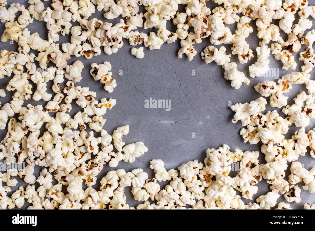 Frame of fresh popcorn on grey stone background. Top view with copy ...