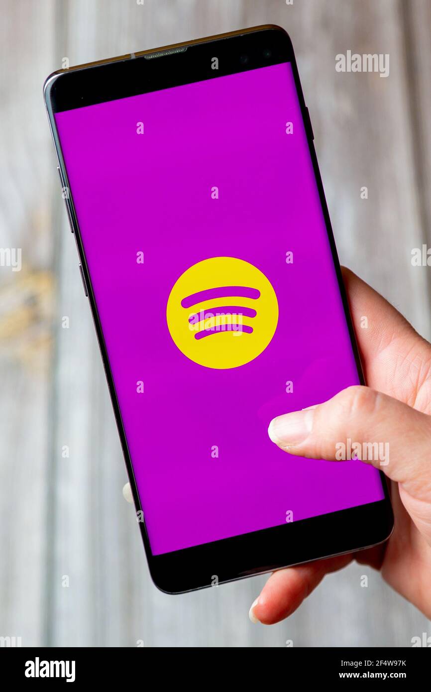 A mobile phone or cell phone being held in a hand with the Spotify Kids ...