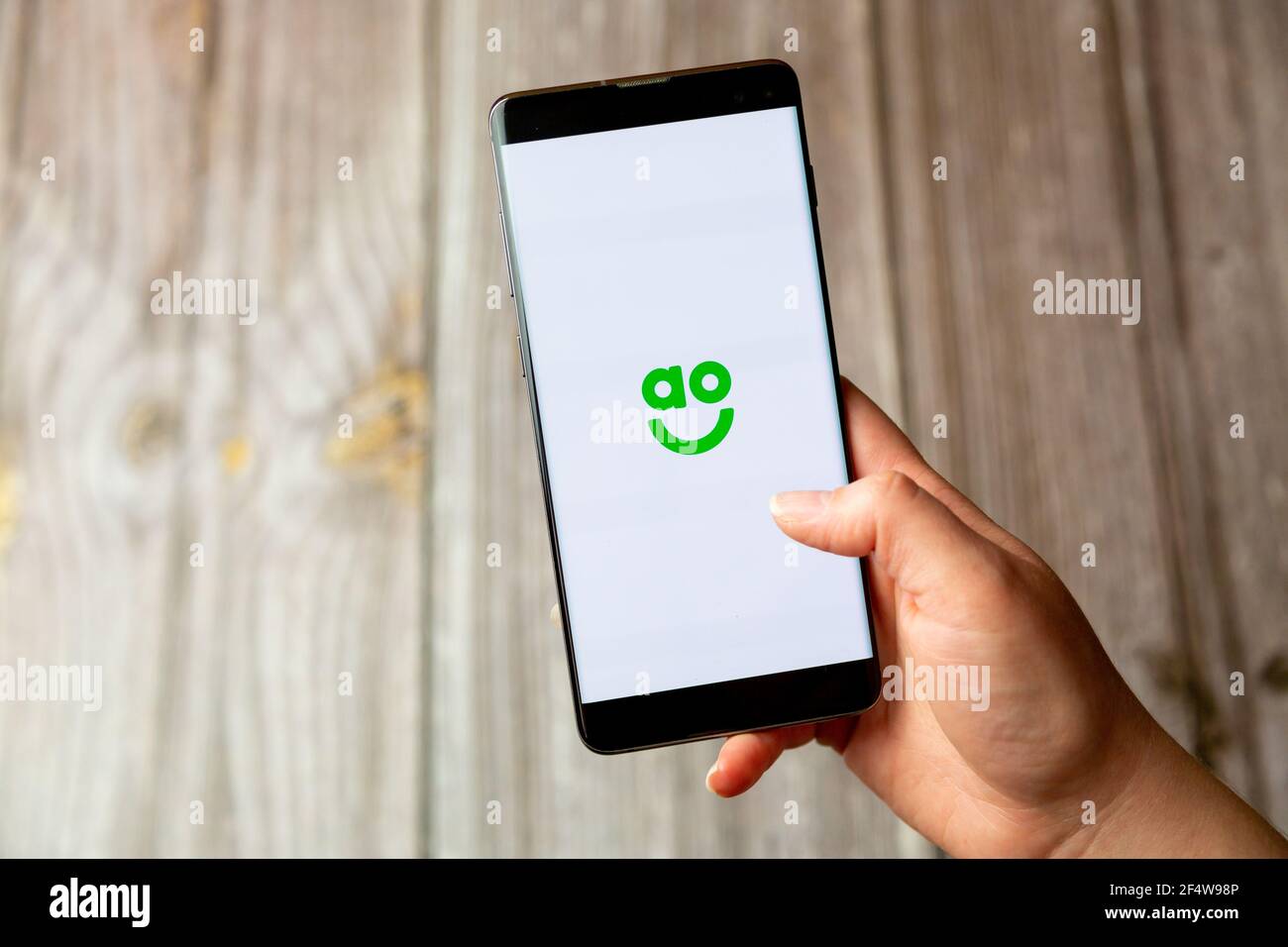 A mobile phone or cell phone being held in a hand with the AO shopping ...