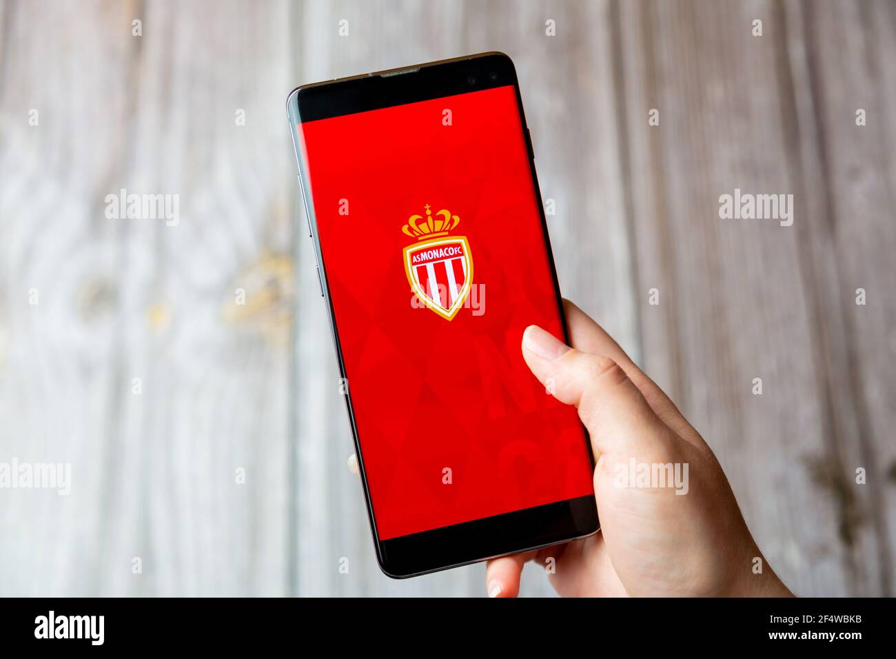 A mobile phone or cell phone being held in a hand with the AS Monaco ...
