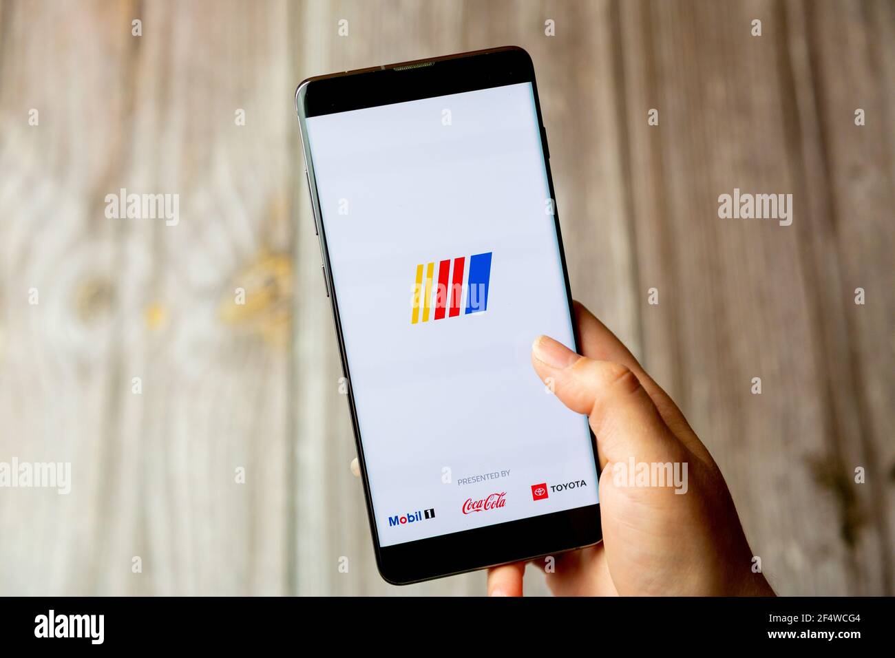 A mobile phone or cell phone being held in a hand with the Nascar ...